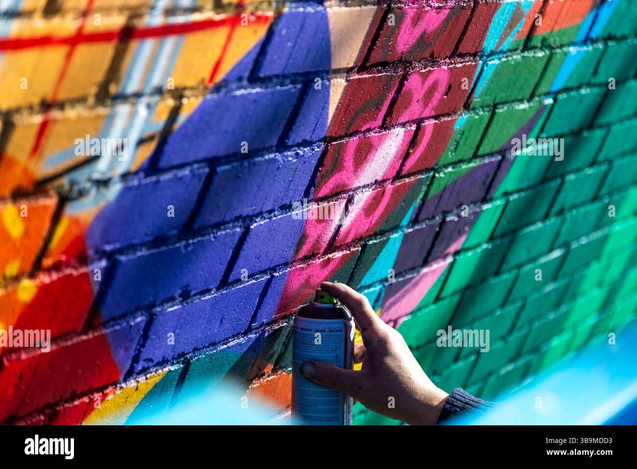 Artist Louis Masai working on a mural for Hit the North Translink ...