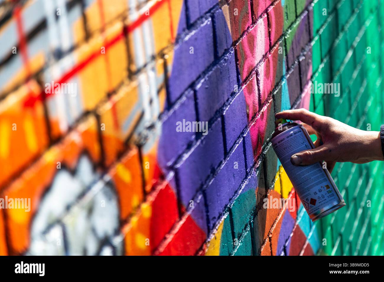 Artist Louis Masai working on a mural for Hit the North Translink ...