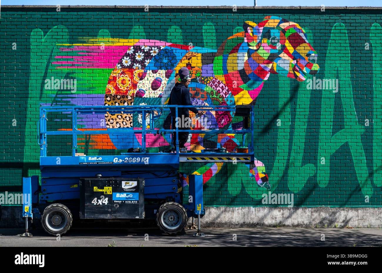 Artist Louis Masai working on a mural for Hit the North Translink ...