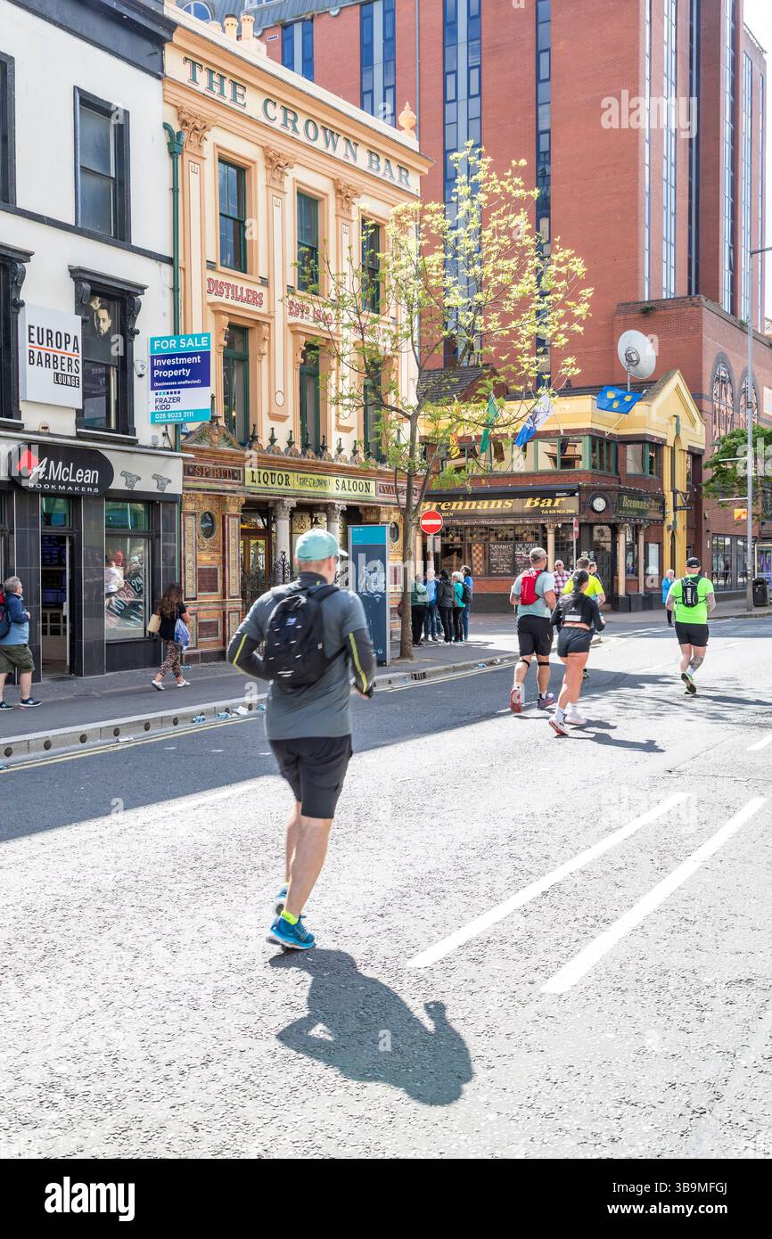Runners in the Belfast Marathon jog past the famous Crown Bar, Belfast ...
