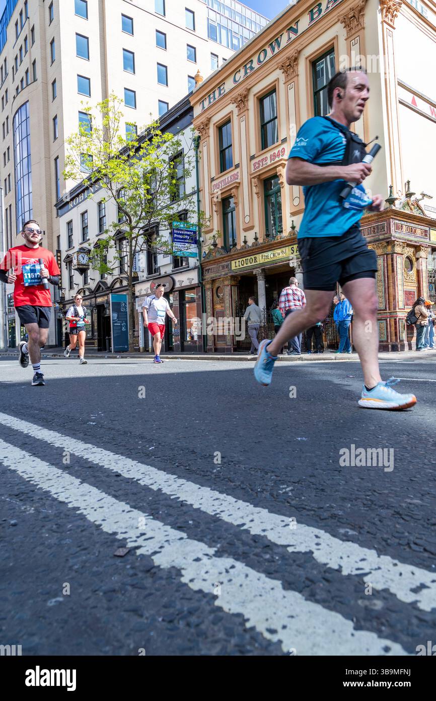 Runners in the Belfast Marathon jog past the famous Crown Bar, Belfast ...