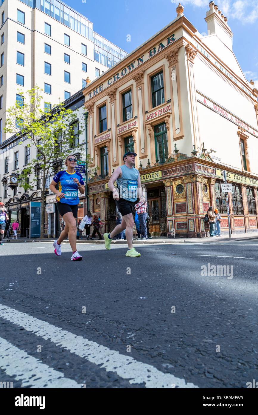 Runners in the Belfast Marathon jog past the famous Crown Bar, Belfast ...