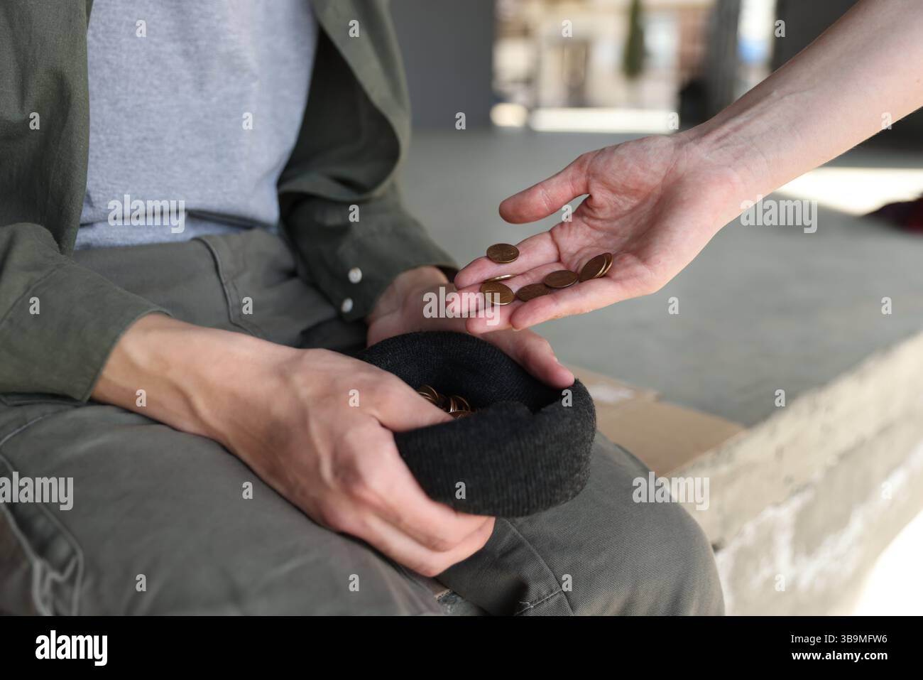 Woman giving money to homeless man outdoors, closeup Stock Photo - Alamy