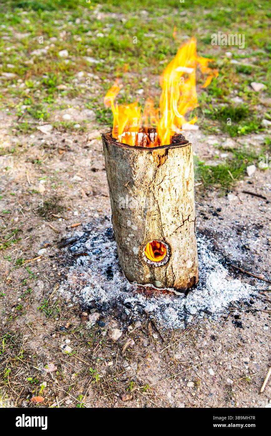 Round wood log with chopped out middle and side hole for burning fire ...