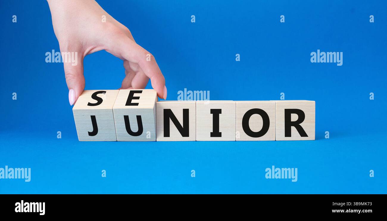 Senior and Junior symbol. Businessman hand turns wooden cubes and ...