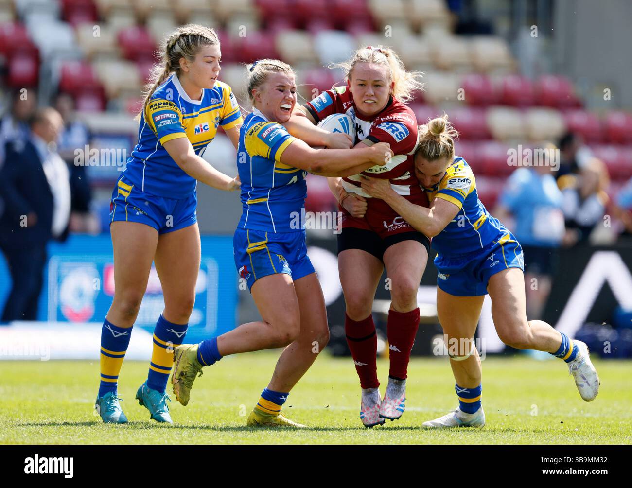 Wigan Warriors' Mary Coleman (second right) is tackled by Leeds Rhinos ...