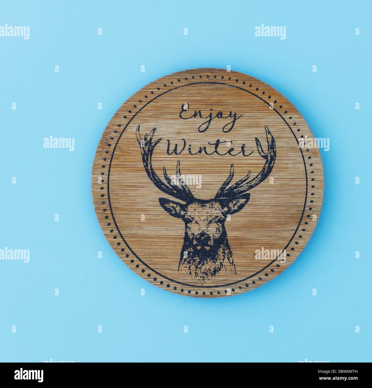 A round wooden coaster with a rustic engraved design featuring a ...