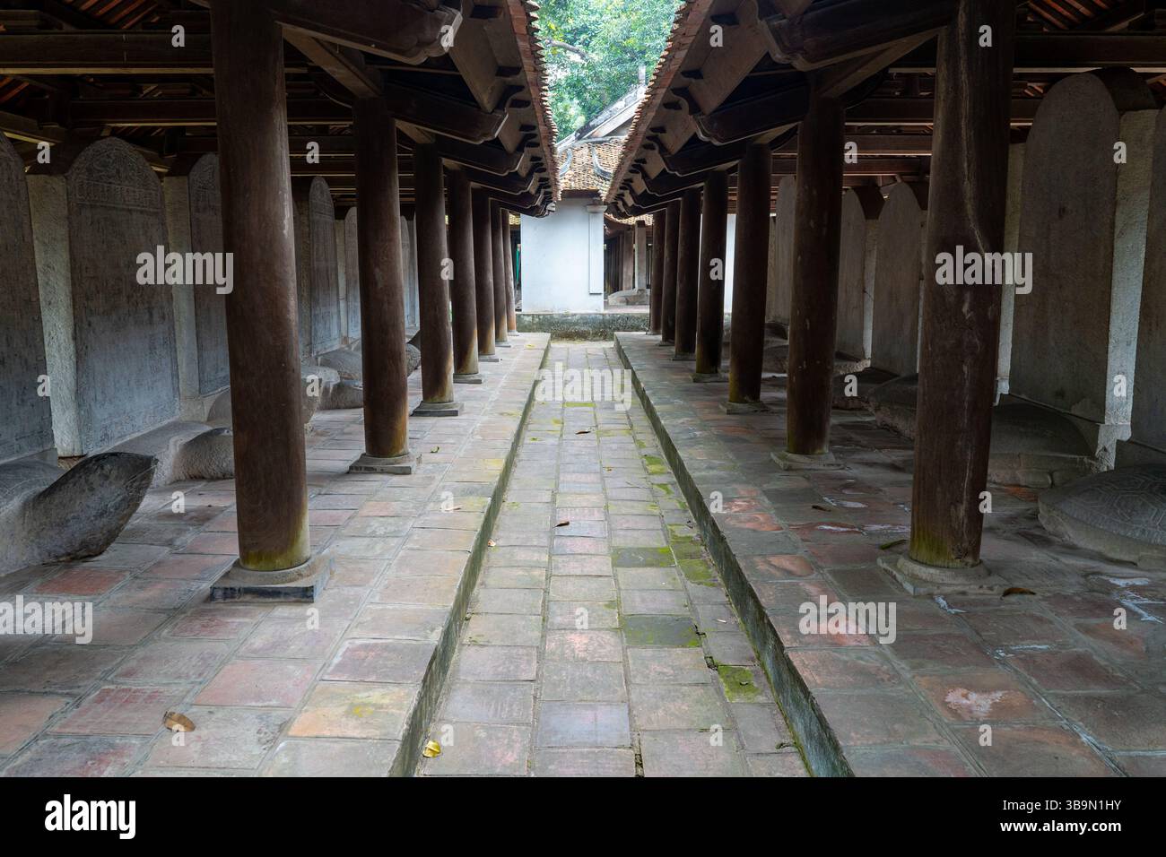 An inside view of an old Vietnamese temple with pillars, stone ...