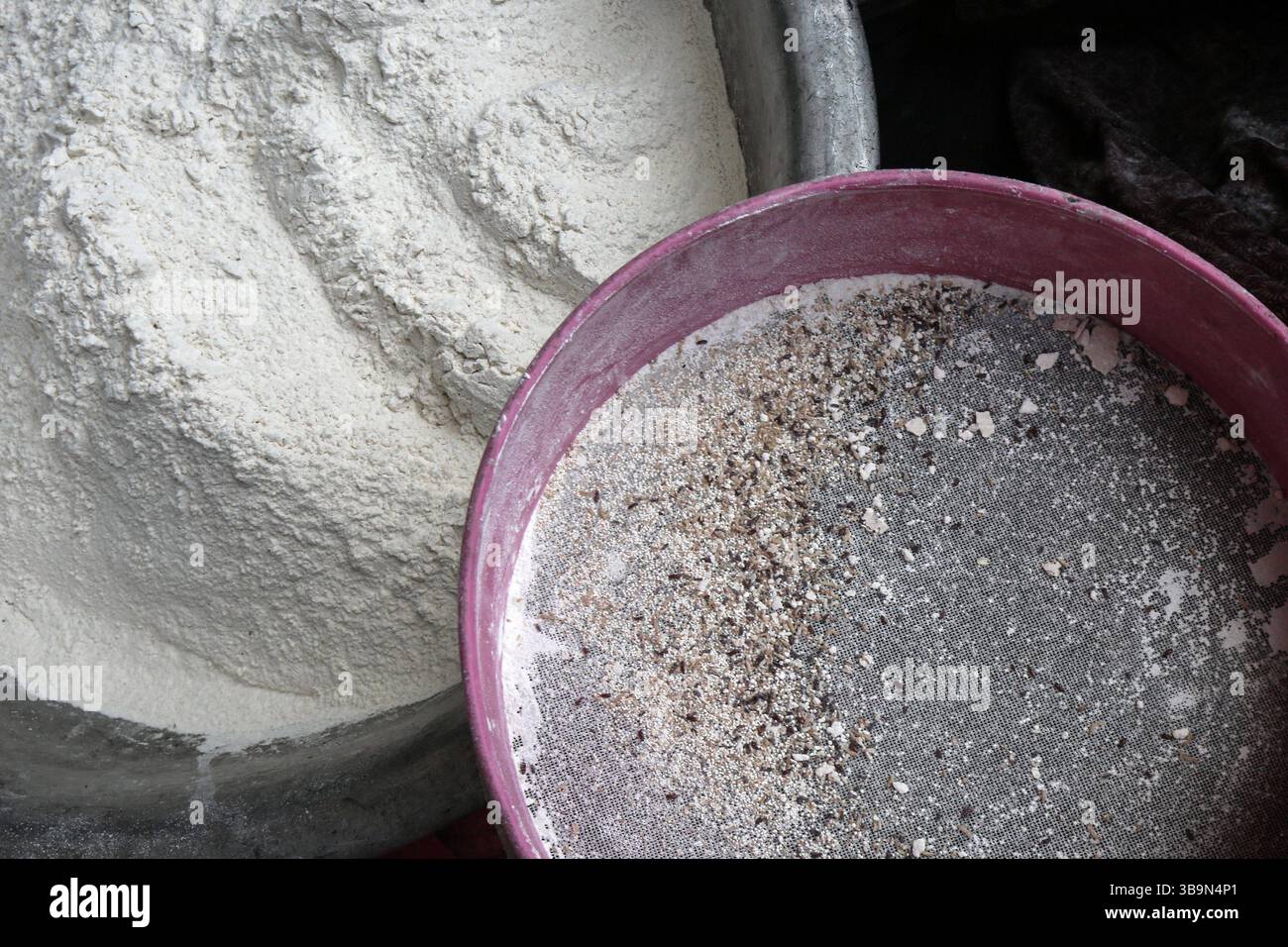 A Palestinian woman prepares bread using stale and spoiled flour as the ...