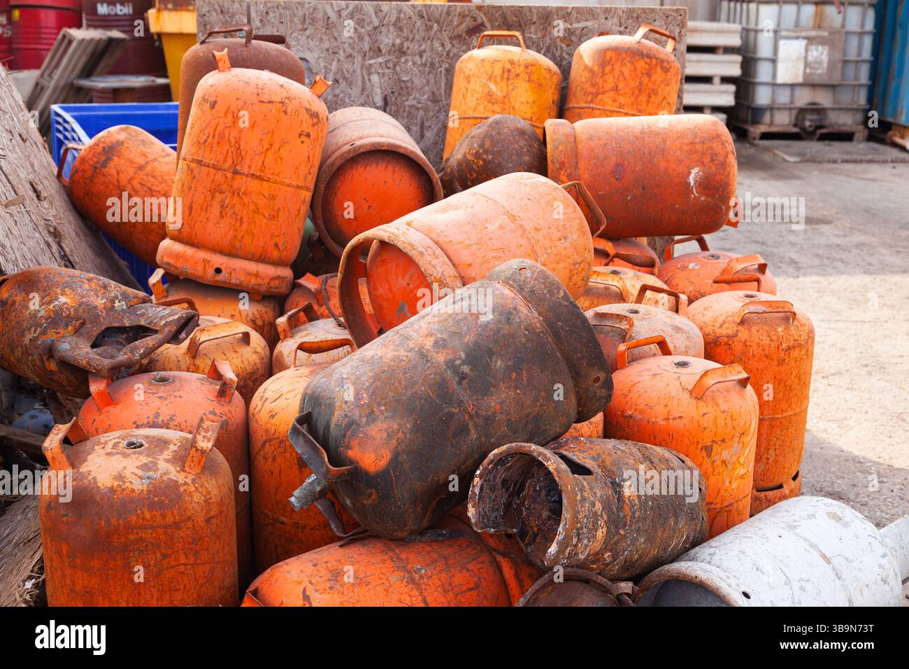 A pile of old used gas cylinders of small size. Scrap metal from gas ...