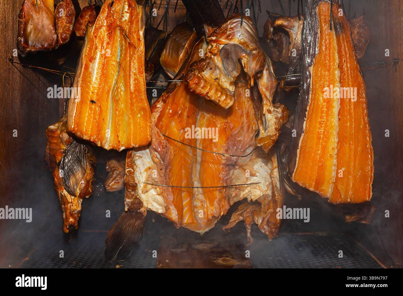 Smoking fish in a smokehouse. The fish hangs in the smokehouse and is ...