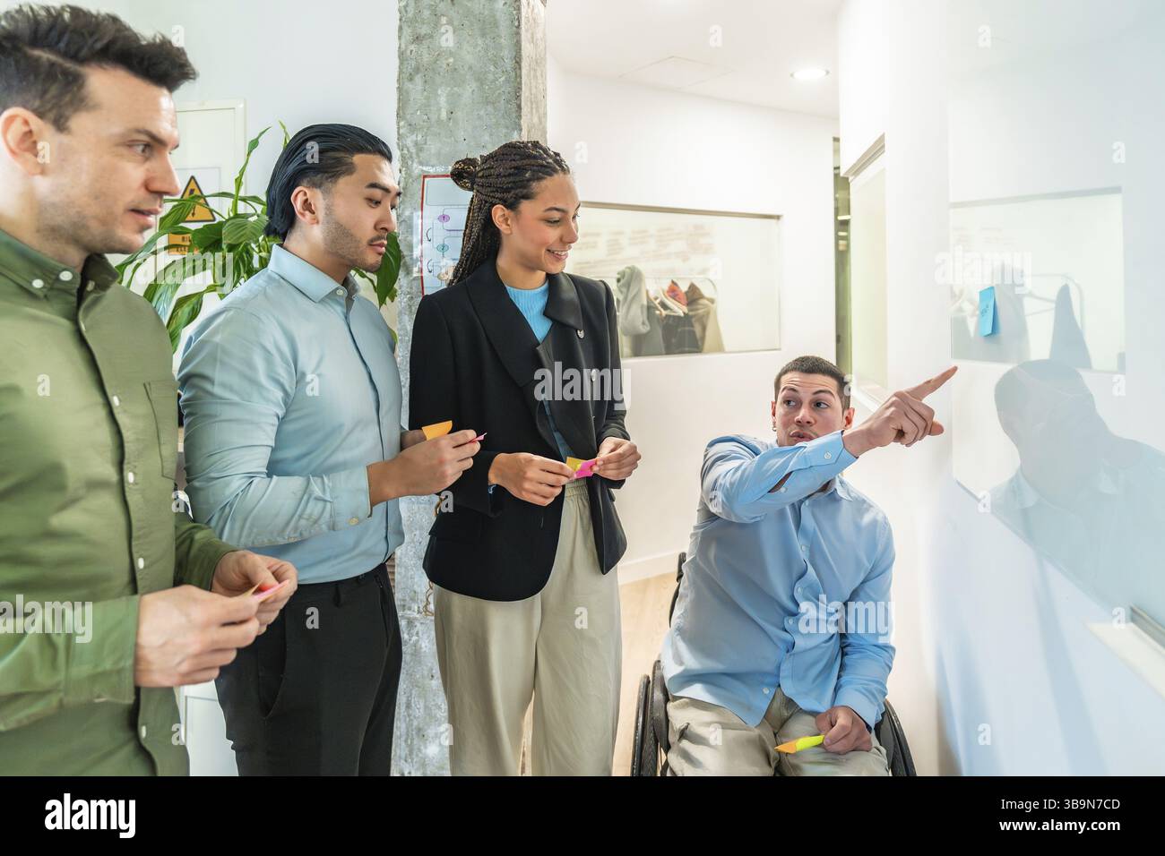 Diverse young professionals brainstorming with sticky notes on a ...