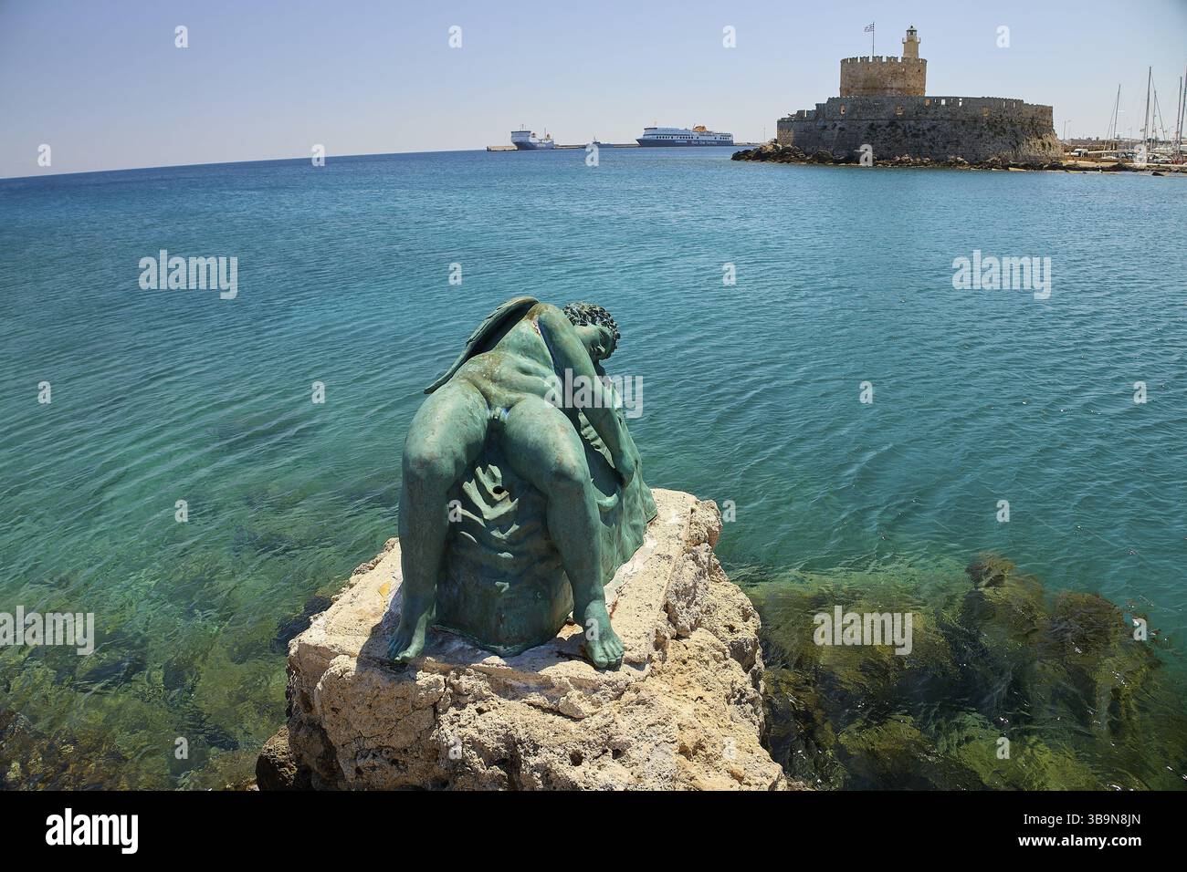 Bronze sculpture, sleeping Eros, in front of a castle by the sea on a ...
