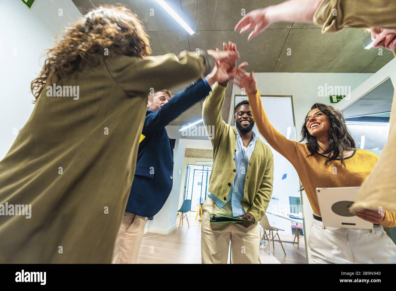Coworkers joining hands, celebrating successful teamwork and ...