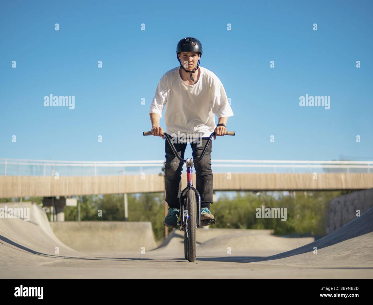 Young BMX bicycle rider having fun and rides in concrete skatepark ...