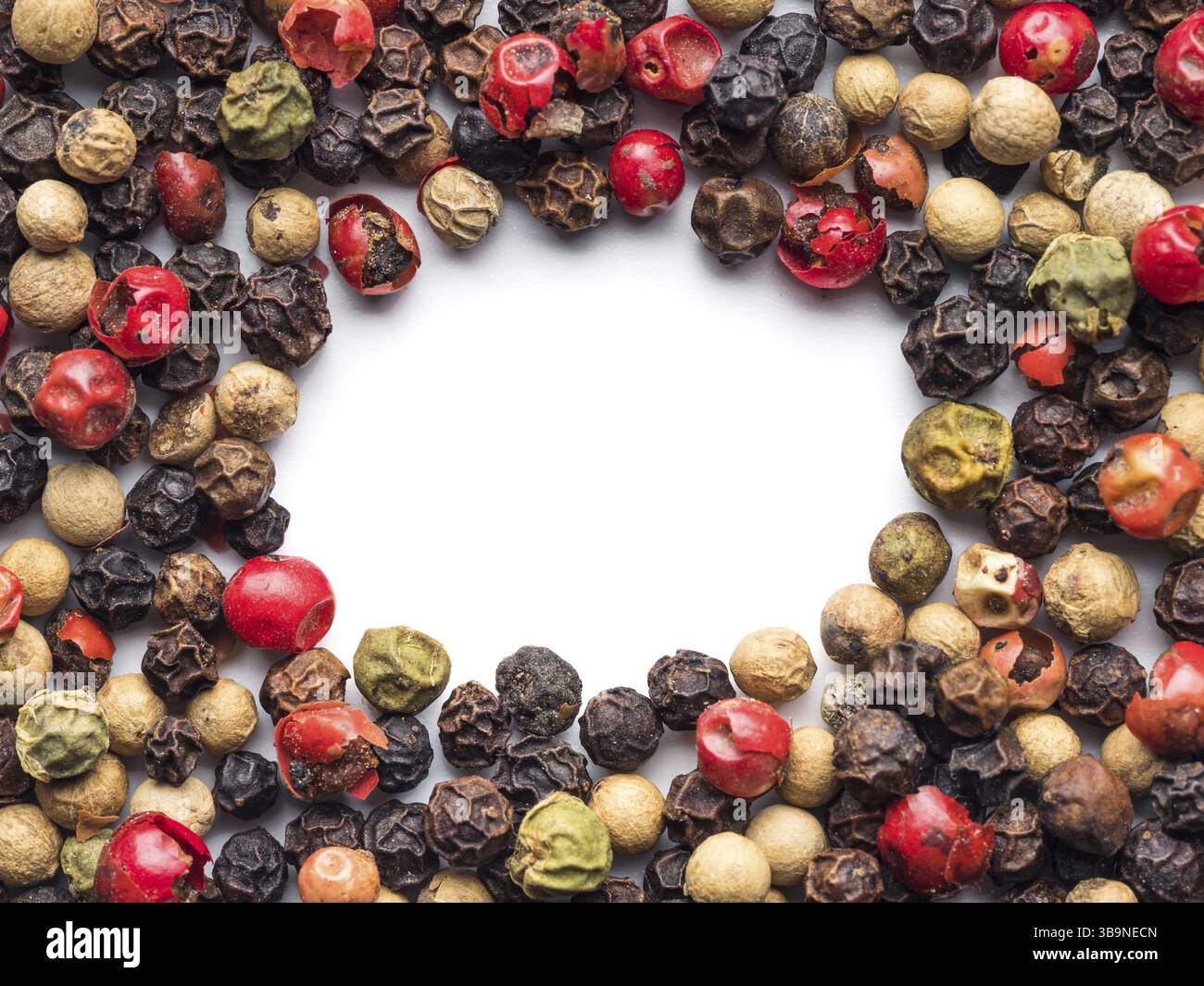 Mixed peppercorns background with white copy space in center. Food ...