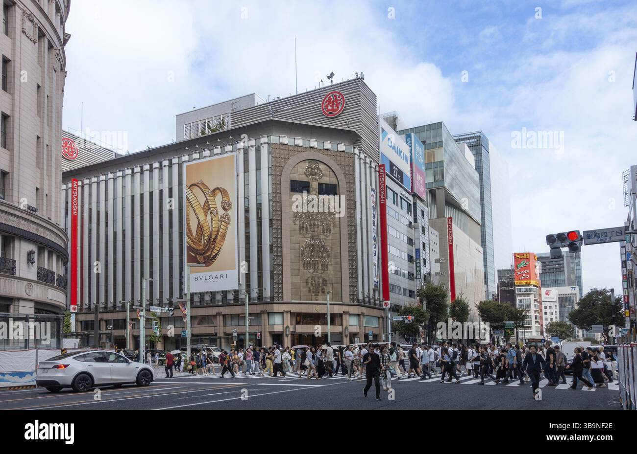 Pedestrians crossing the road in front of the Mitsukoshi Ginza ...