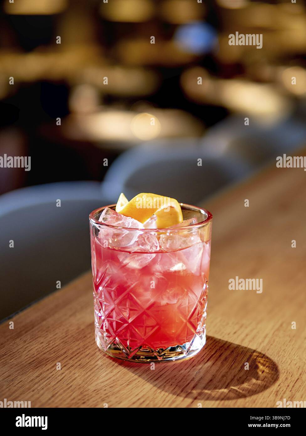 Transparent pink alcohol cocktail with ice, aperol and gin on bar ...