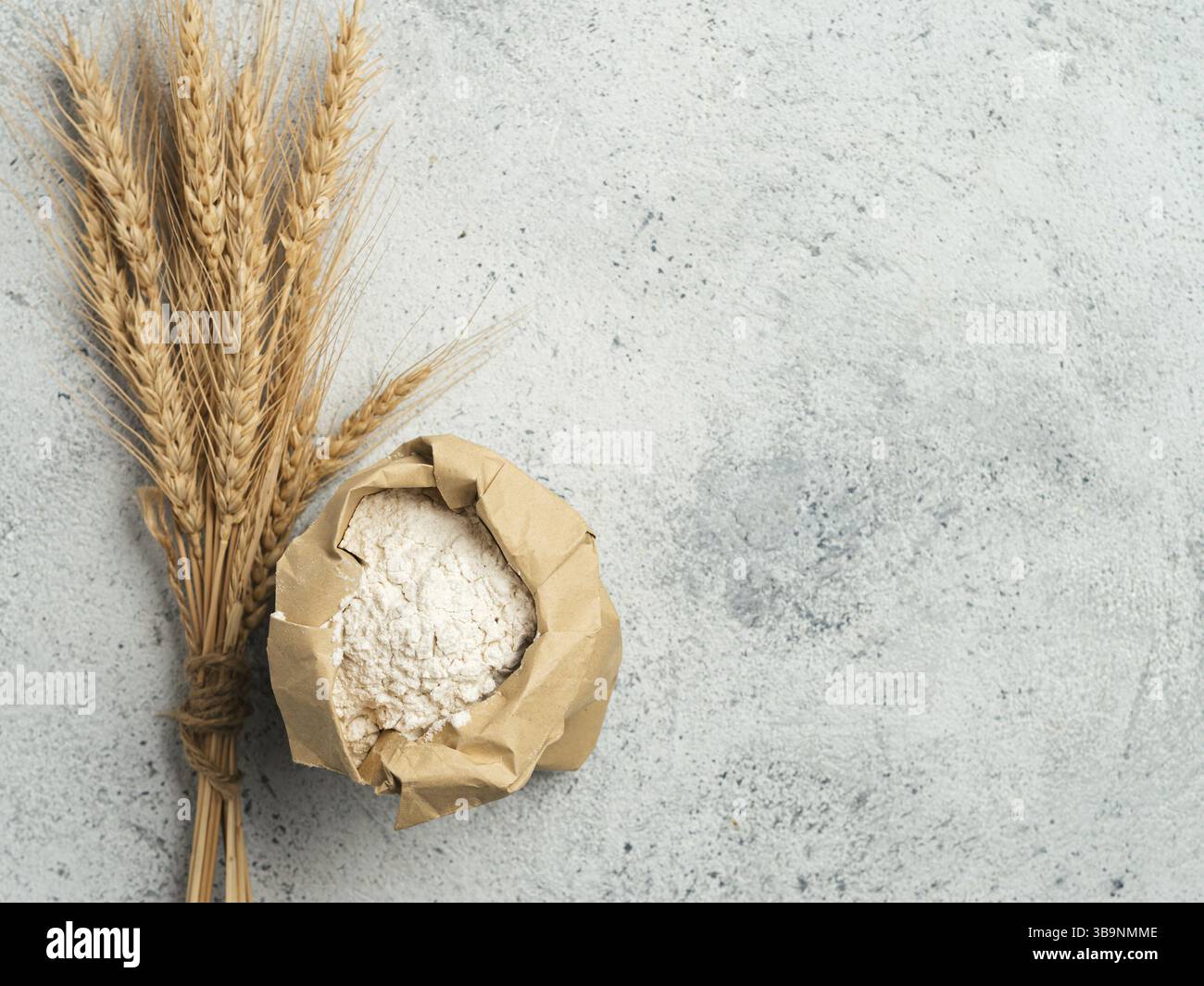 Wheat flour in paper bag and spikes over gray cement background. Food ...