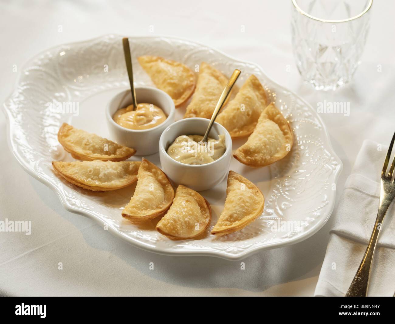 Hot Appetizers with Mini Chebureki and sauces Isolated on white table ...