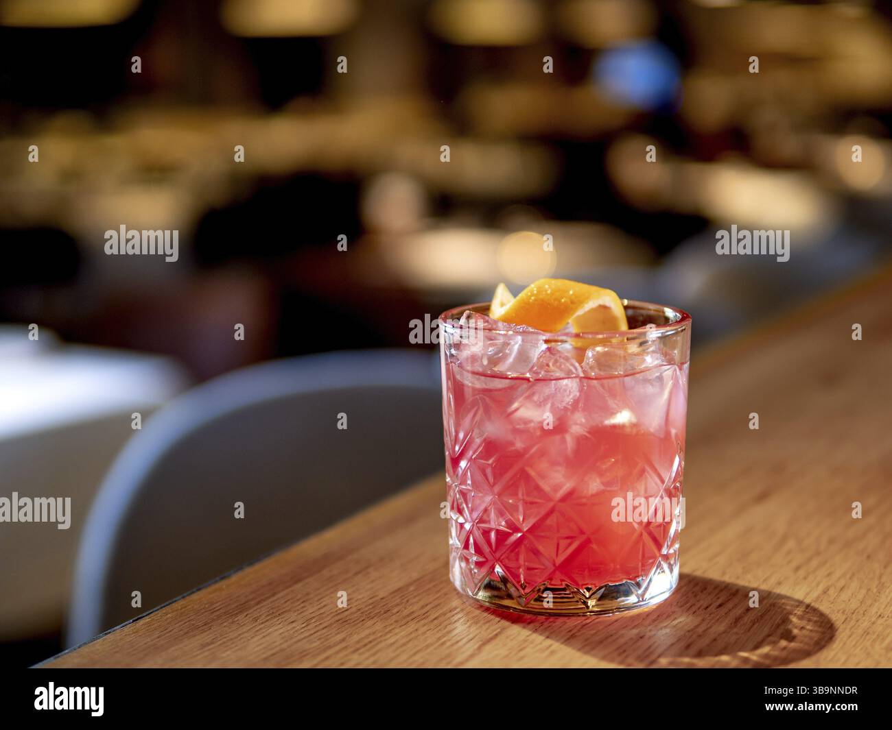 Transparent pink alcohol cocktail with ice, aperol and gin on bar ...