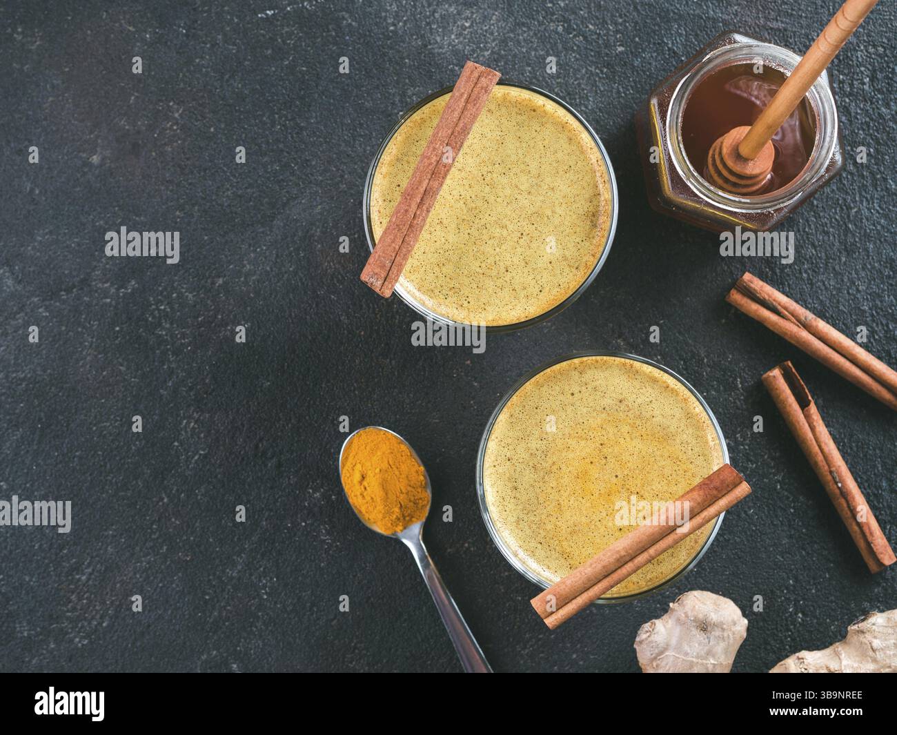 Healthy drink golden turmeric latte in glass. Gold milk, ginger root ...