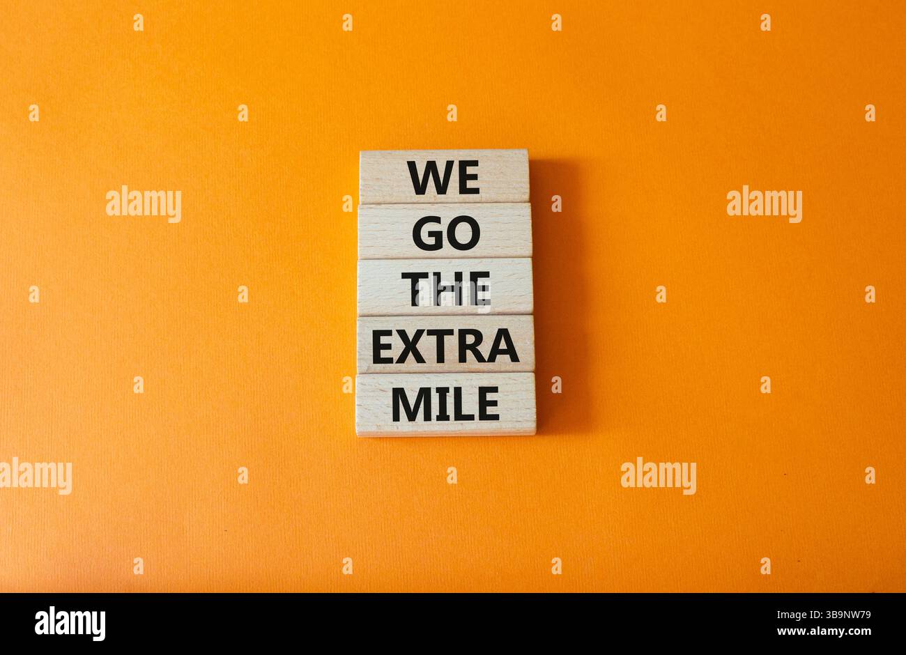 We go the extra mile symbol. Wooden blocks with words We go the extra ...