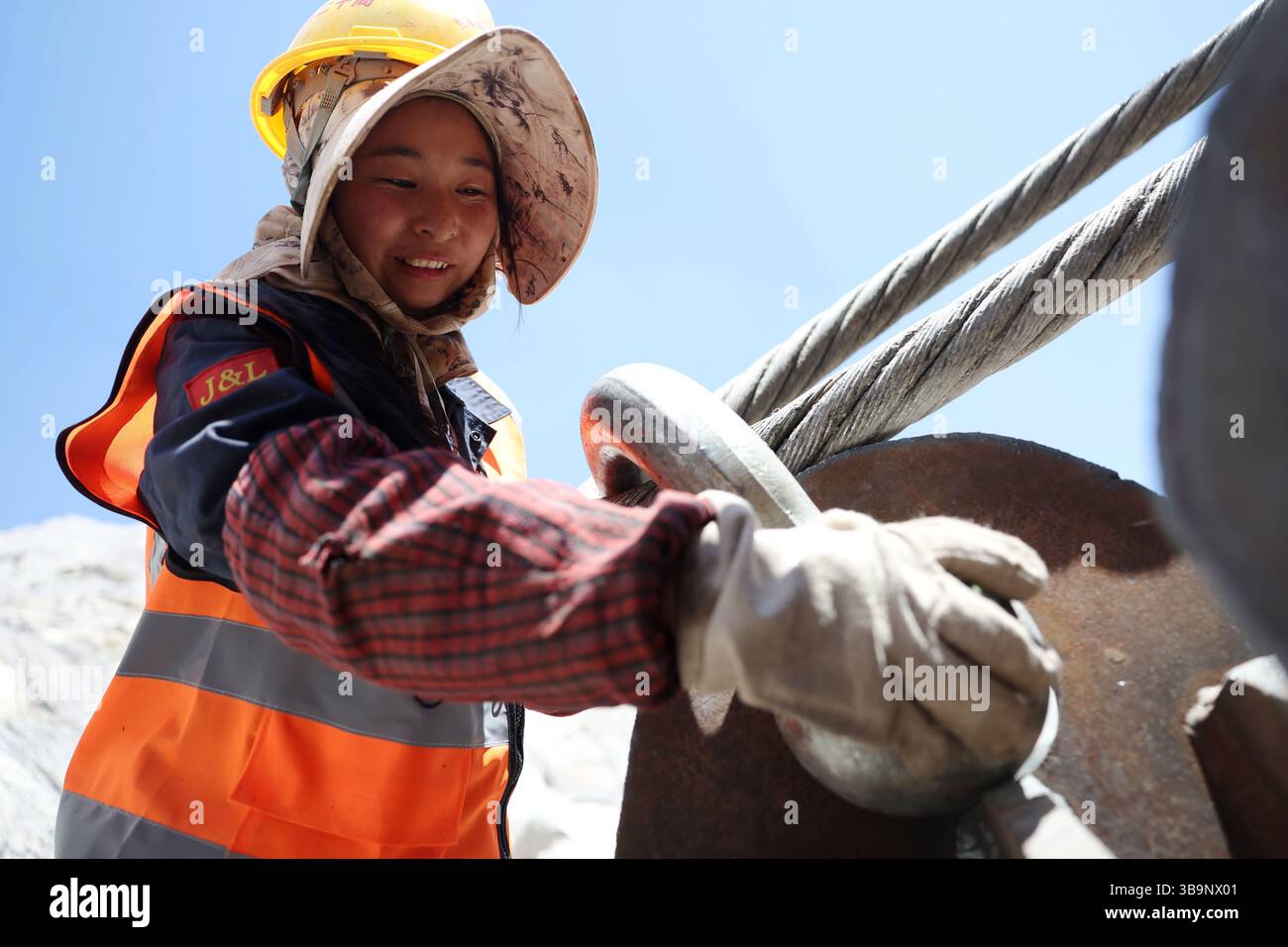 Yongjing. 10th May, 2025. A staff member works on trial hoisting of a ...