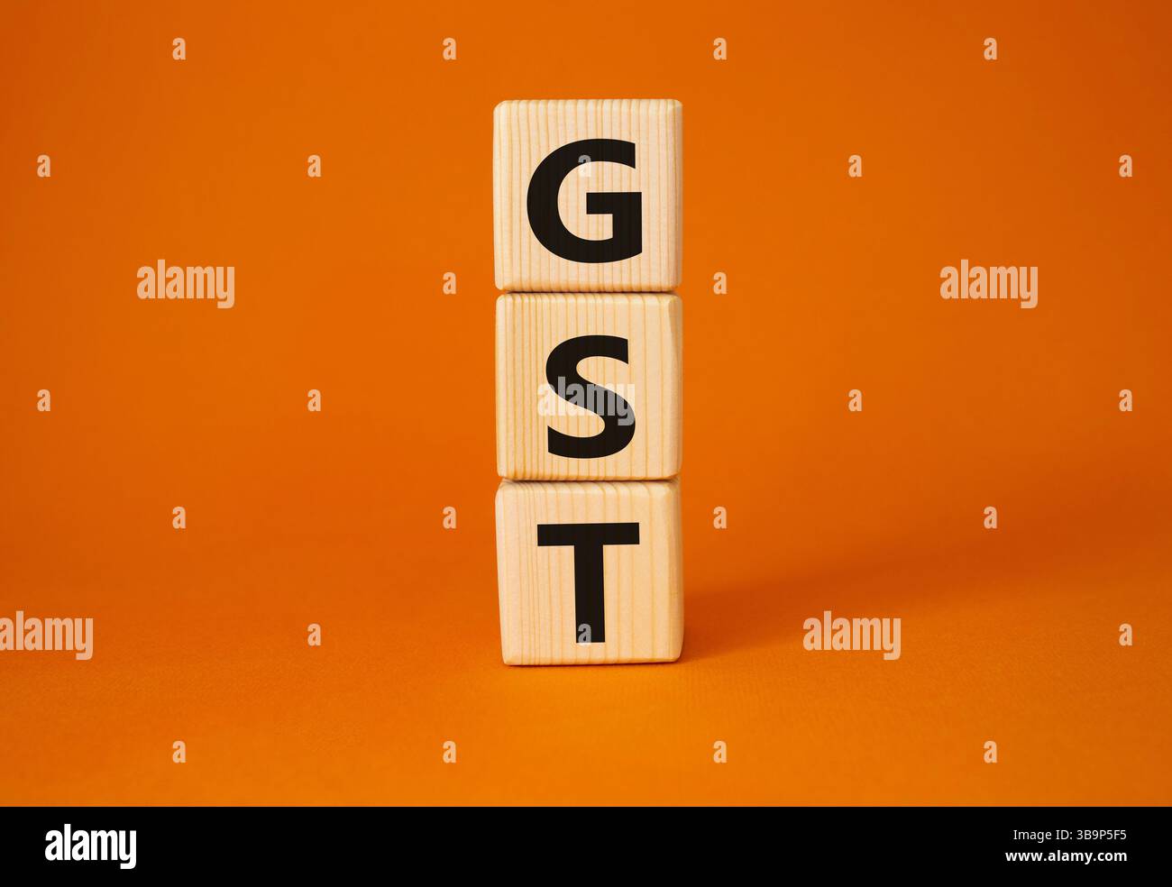 GST - Goods and Services Tax symbol. Concept word GST on wooden cubes ...