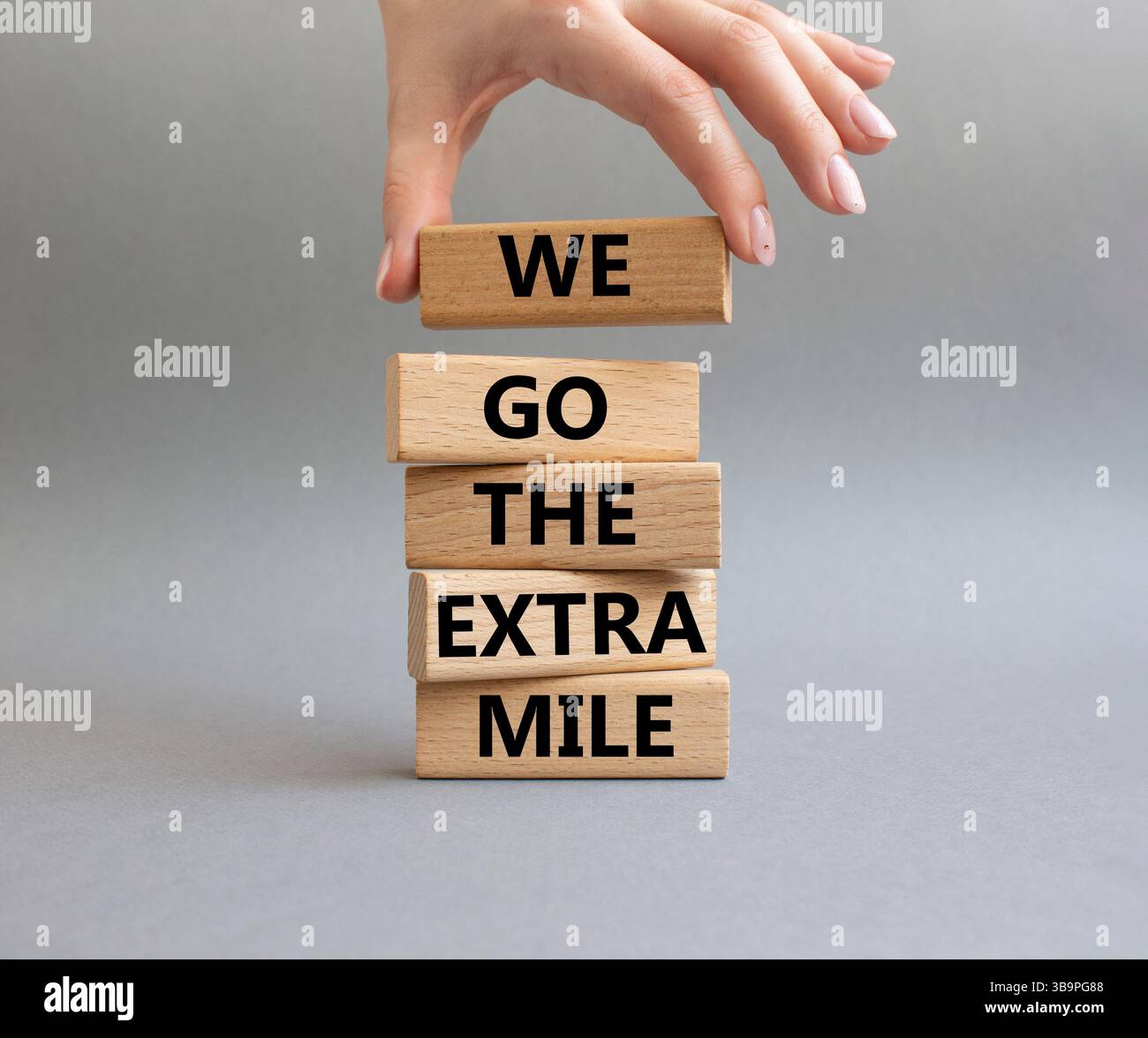 We go the extra mile symbol. Wooden blocks with words 'We go the extra ...