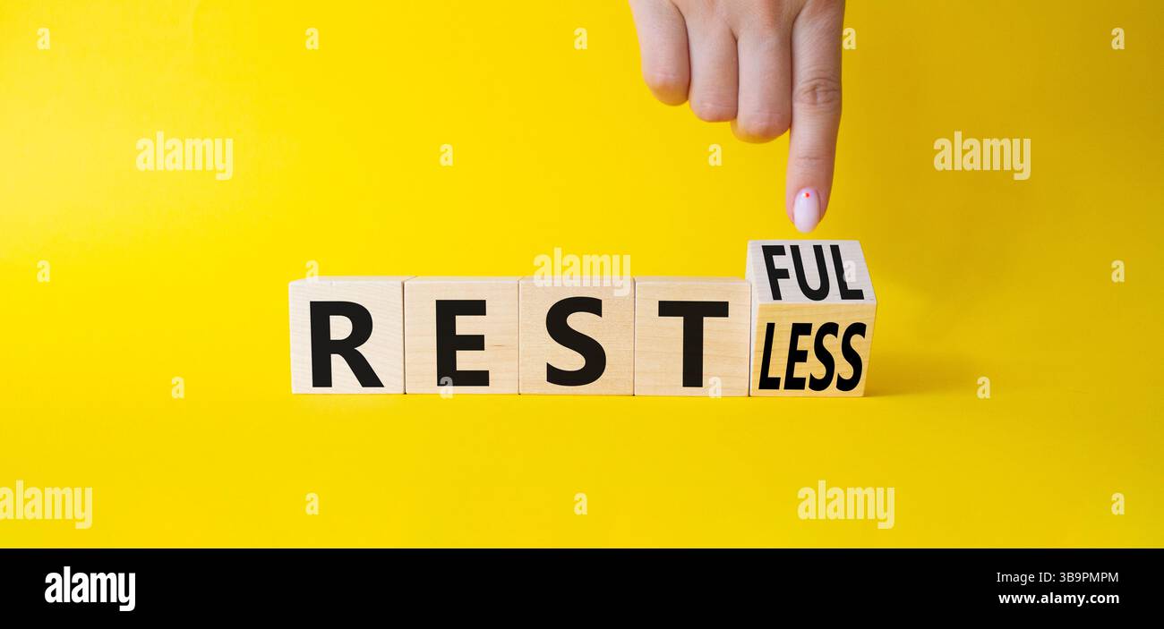 Restful and Restless symbol. Businessman points at wooden cubes with ...