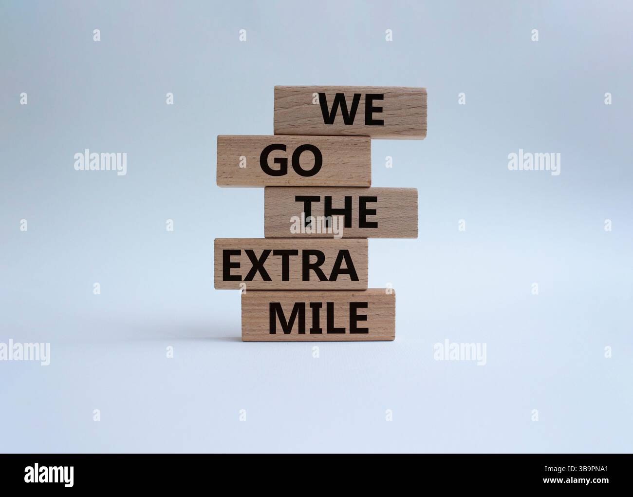 We go the extra mile symbol. Wooden blocks with words 'We go the extra ...