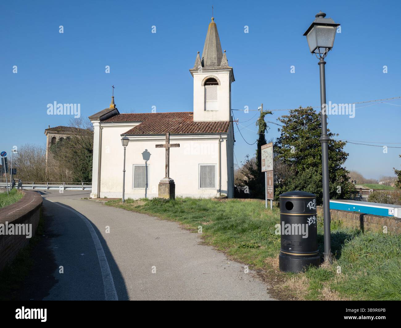 Rural Chapel with Cross, Lamp Post and Pathway Under Clear Sky in ...