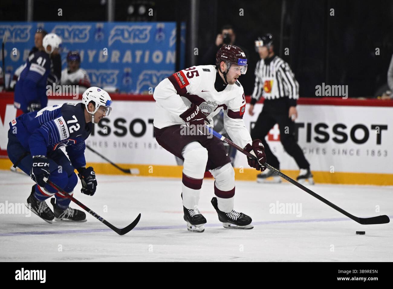 Latvia's Oskar Batna and France's Jordann Perret, left, in action during the IIHF Ice Hockey ...