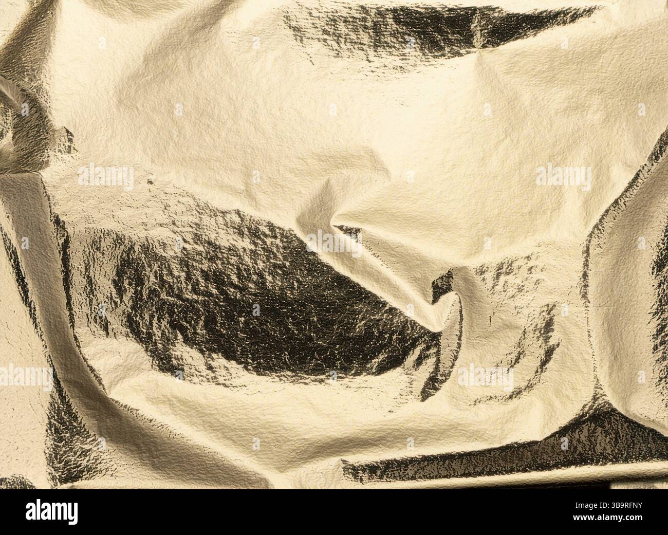 Gold metallic foil texture. Crumpled, shiny, and glossy surface with ...