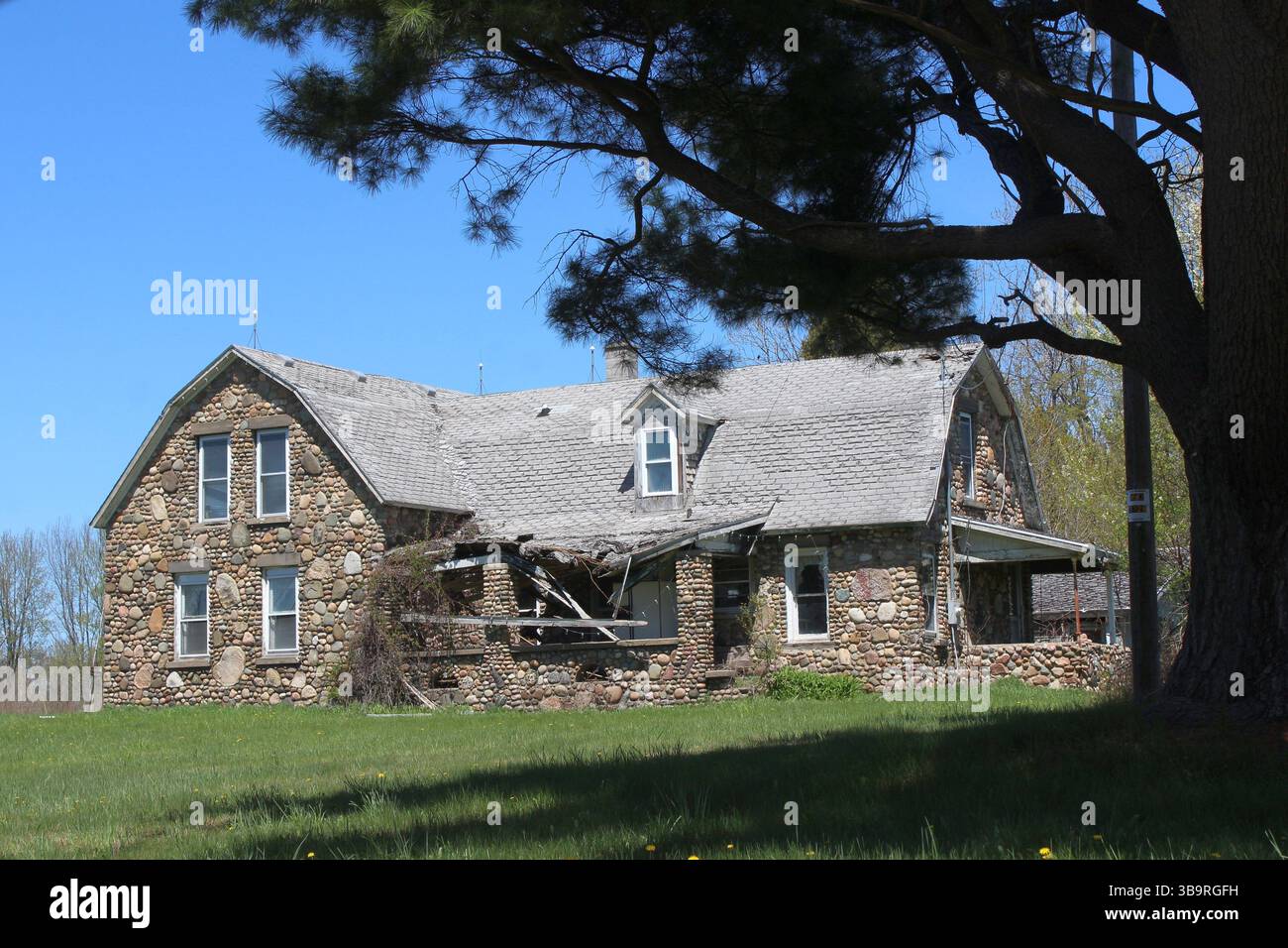 An Old Fieldstone House Under a Pine Tree Stock Photo - Alamy