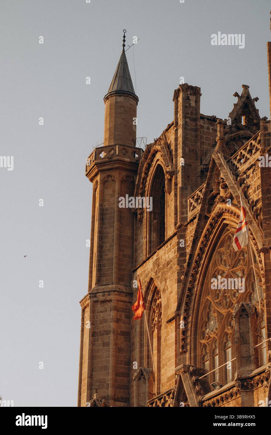 Historic Gothic architecture with a minaret at sunset. A symbol of ...