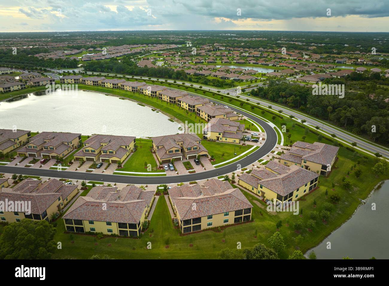 Aerial view of tightly located family houses with retention ponds to ...