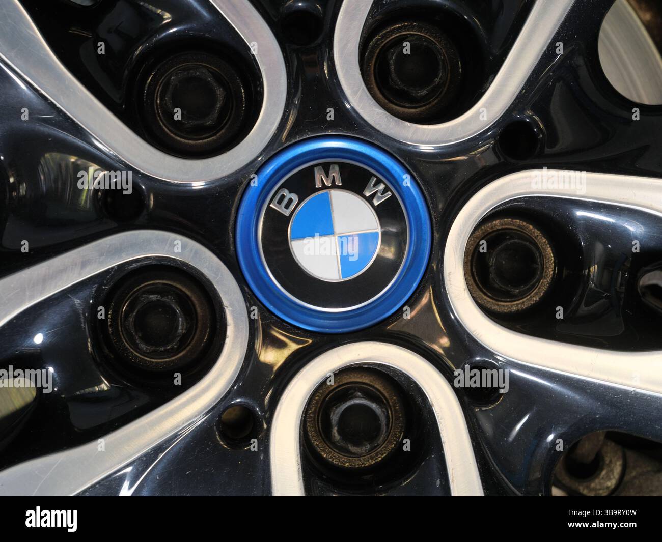 Chrome badge featuring BMW logo mounted on a sleek automotive wheel rim ...