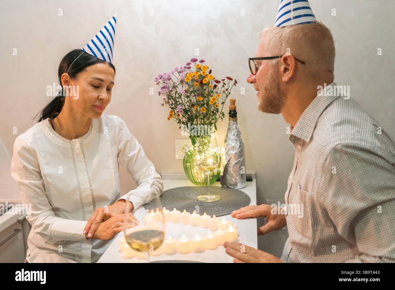 Couple Birthday Cake Celebration Indoors: Man blows candles on birthday ...