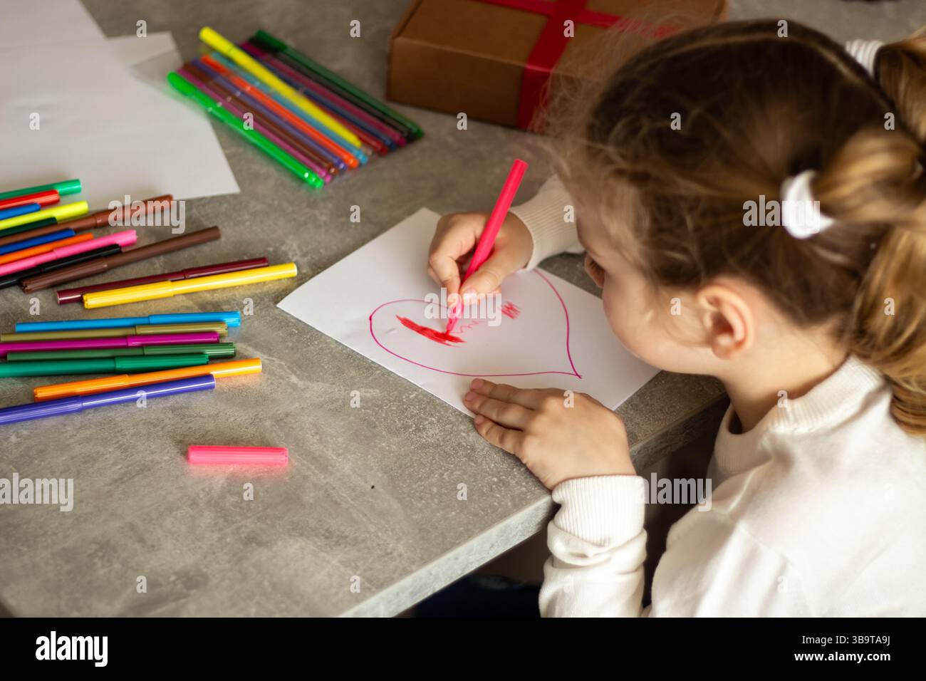 Preschool girl drawing pictures at home table. Natural light, authentic ...