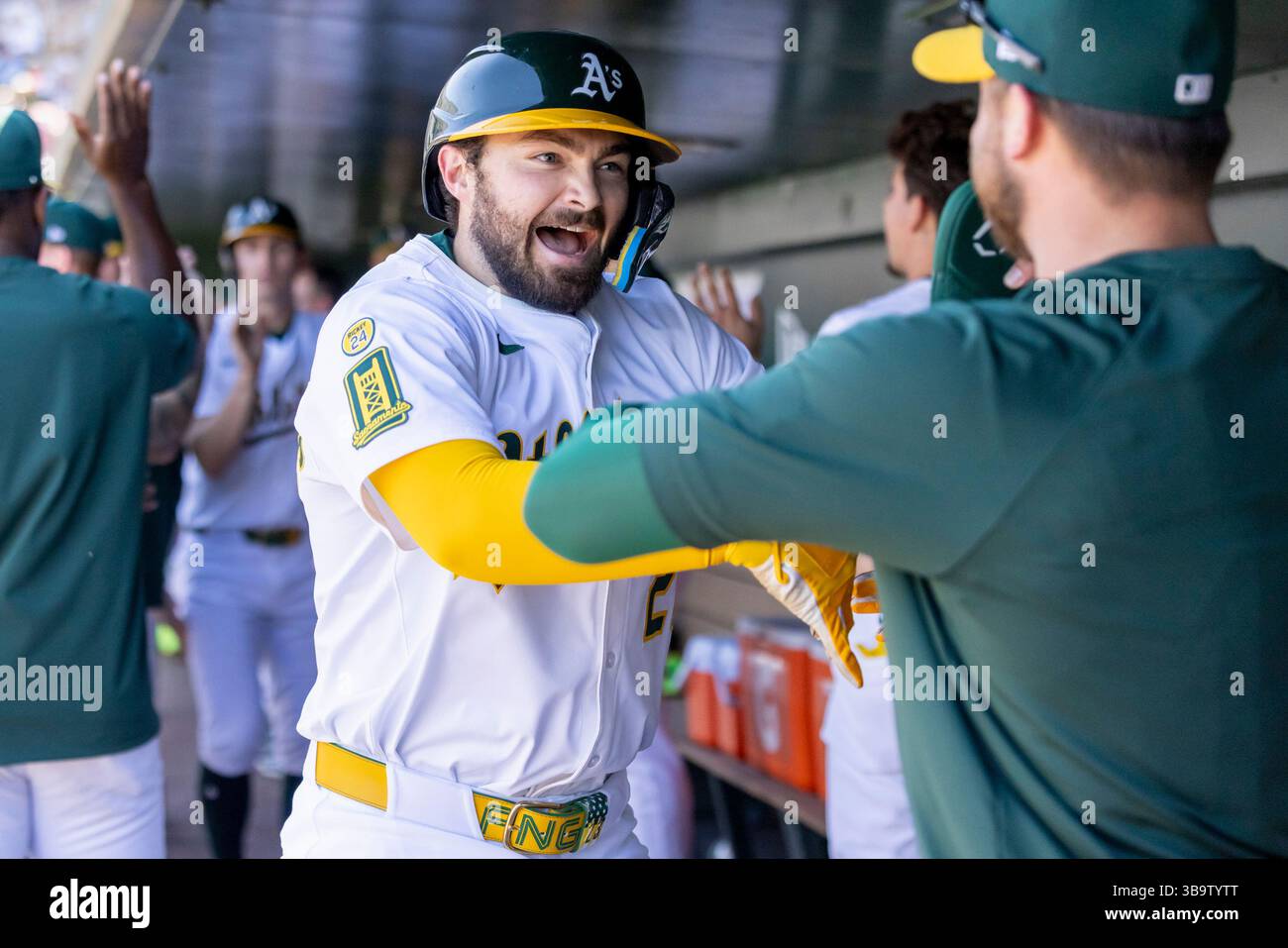 Athletics' Shea Langeliers, left, celebrates in the dugout after ...