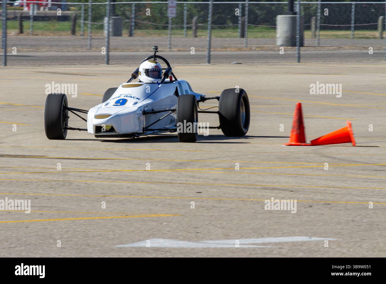 A white race car is driving on a track with a cone in the way Stock ...