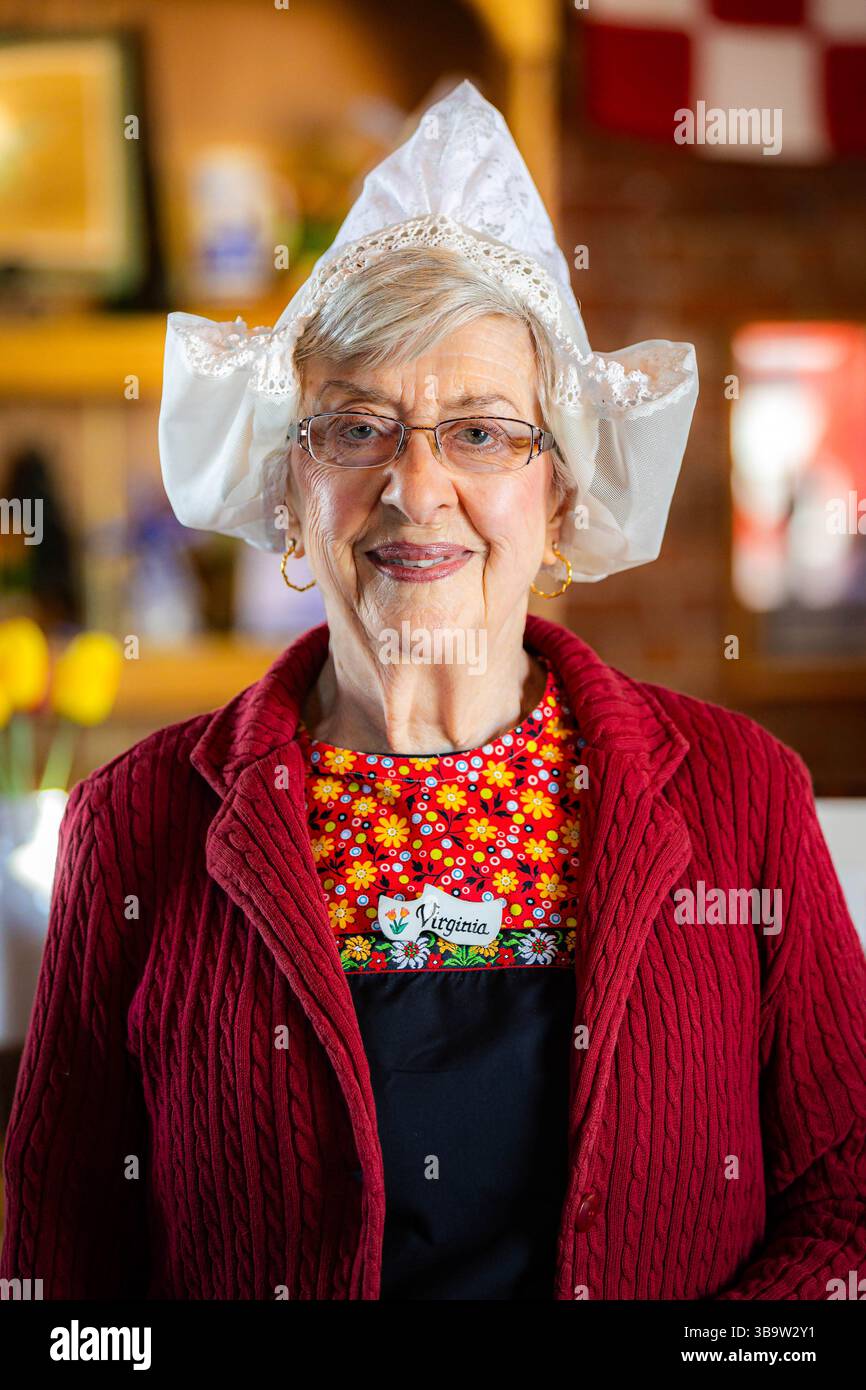 Holland, MI, USA - 04-24-2025: Close-up portrait of smiling old woman dressed in traditional ...