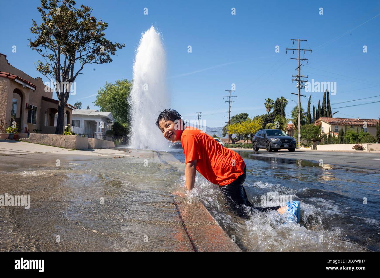 A boy plays in water from a broken fire hydrant in Rosemead, California ...
