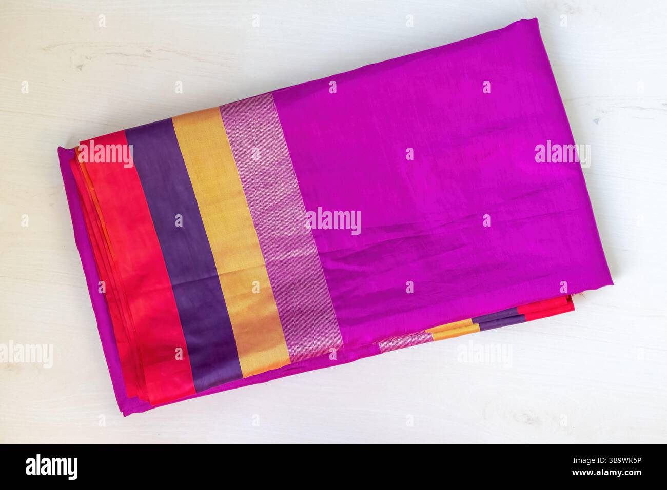 Folded silk saree on a light wooden surface. Most Bengali women wear ...