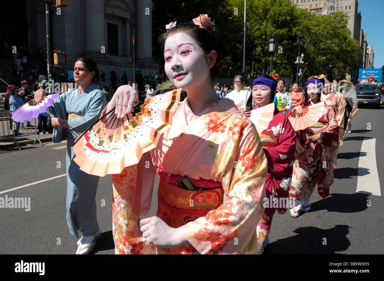 A woman marches wearing traditional Japanese makeup and a kimono in the ...