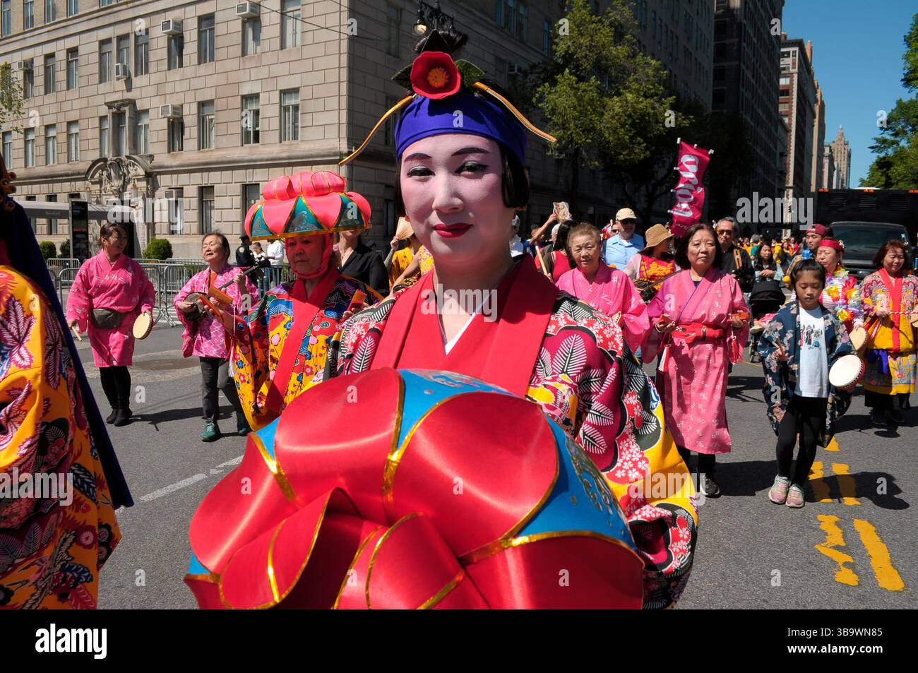 A woman marches wearing traditional Japanese makeup and a kimono in the ...
