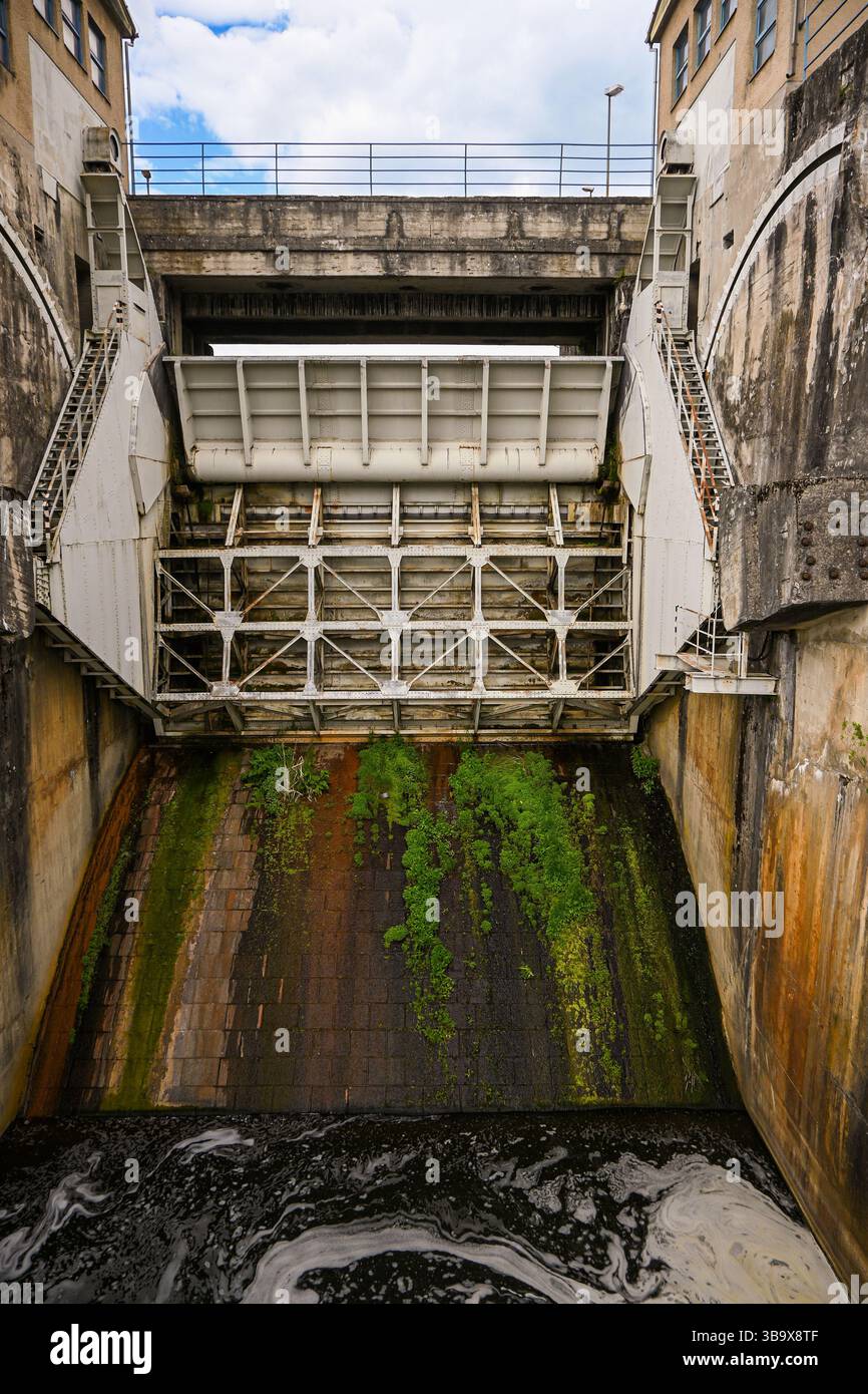 Water flows through a partially open spillway gate at a hydroelectric ...