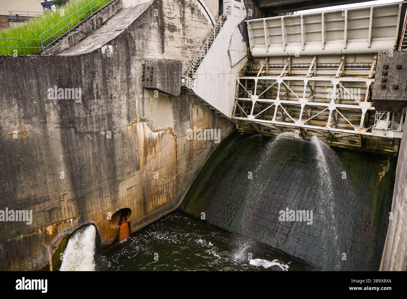 Water flows through a dam spillway, generating hydroelectric power and ...